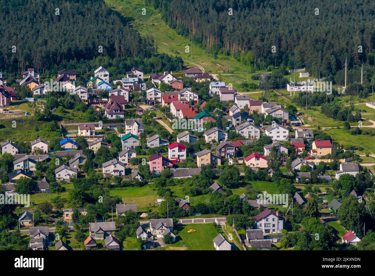 aerial panoramic view of green village with houses, barns and gravel ...