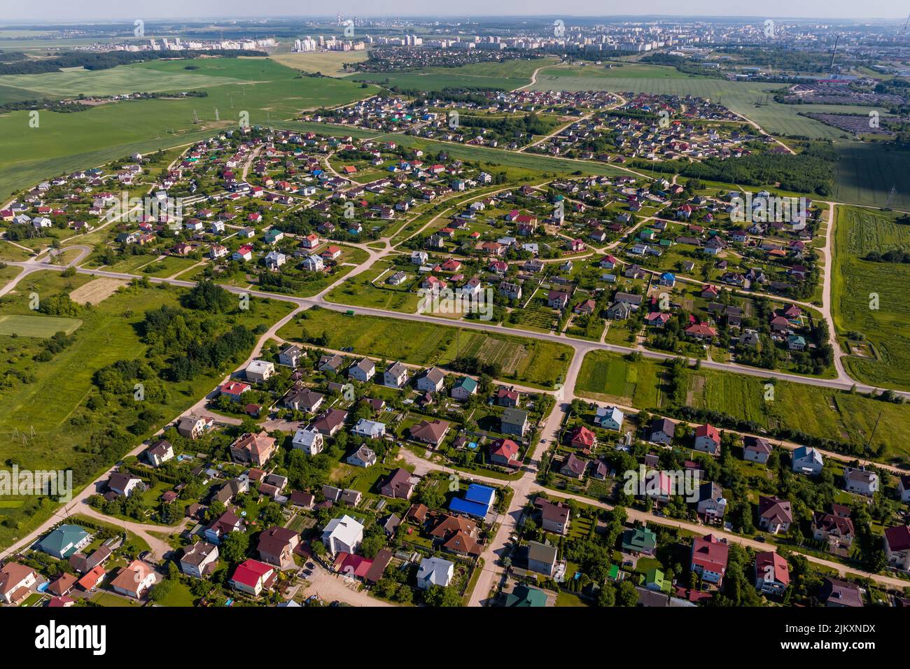 aerial panoramic view of green village with houses, barns and gravel ...