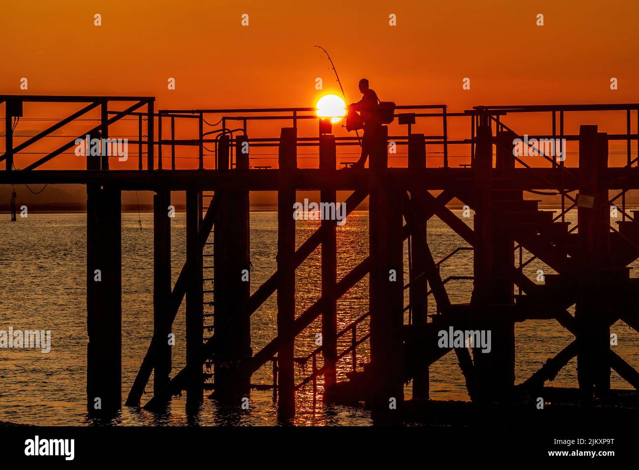 A view of the fisherman returning at the beautiful orange sunset in ...