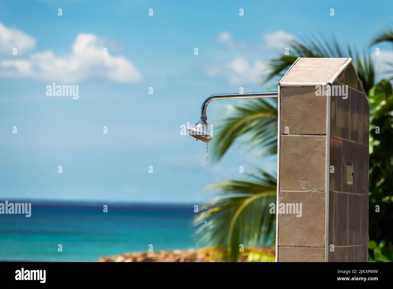 Photo of a metallic shower device in the open air, drops of clear water ...