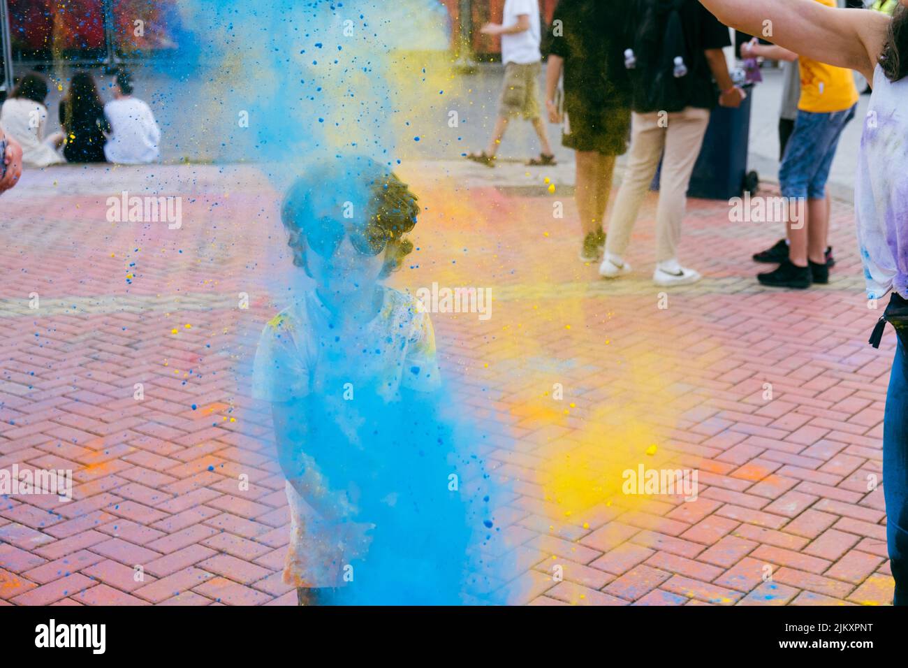 Holi festival. Young cheerful people under explosion of colored powder ...