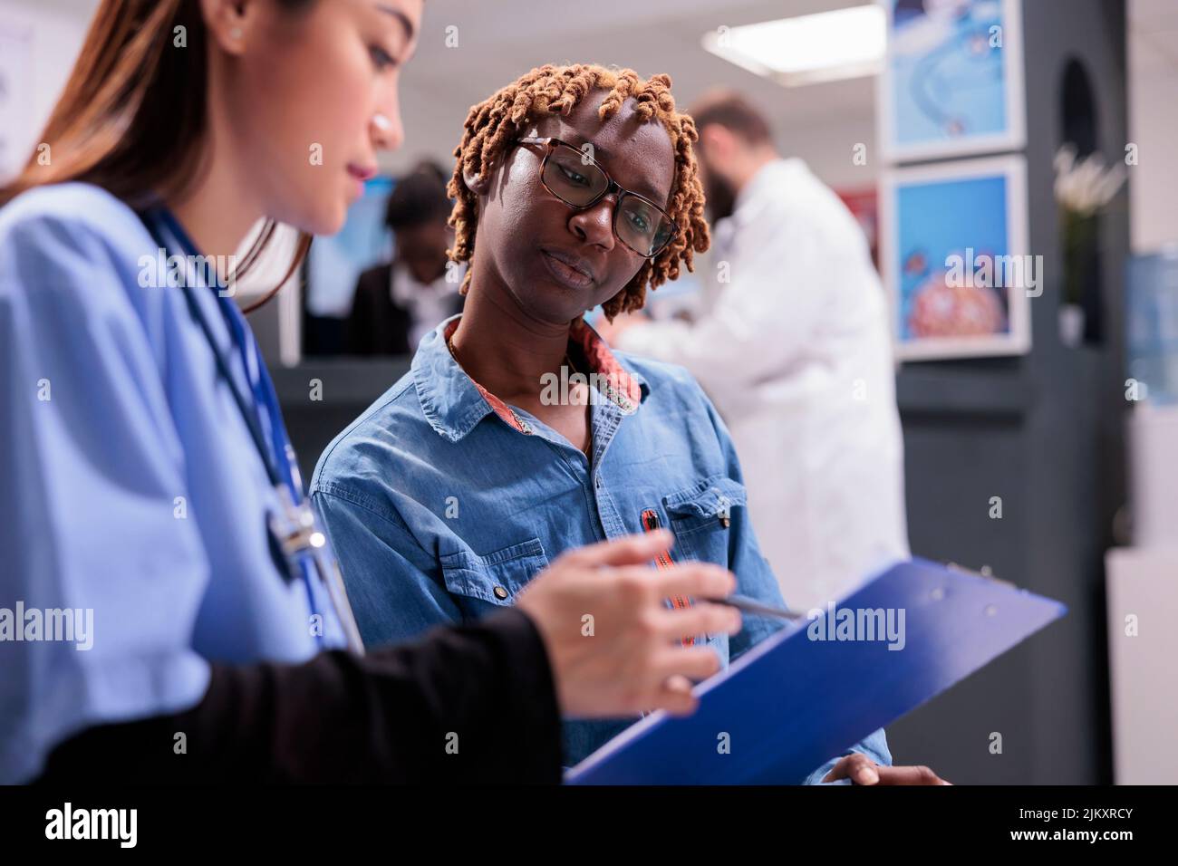 African american patient and nurse looking at report, finding diagnosis ...