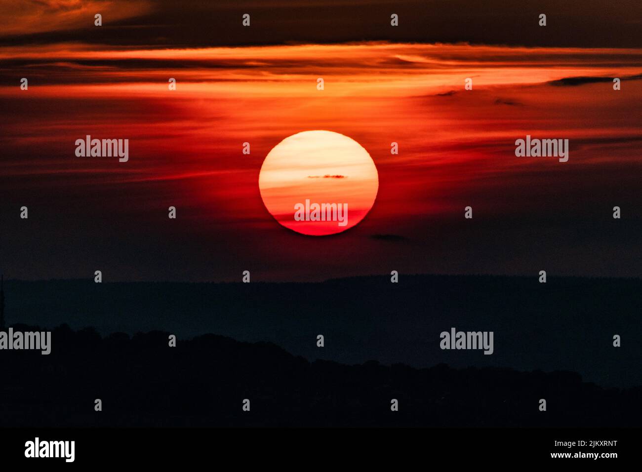 A beautiful view of the sun in the sky at the orange sunset Stock Photo ...