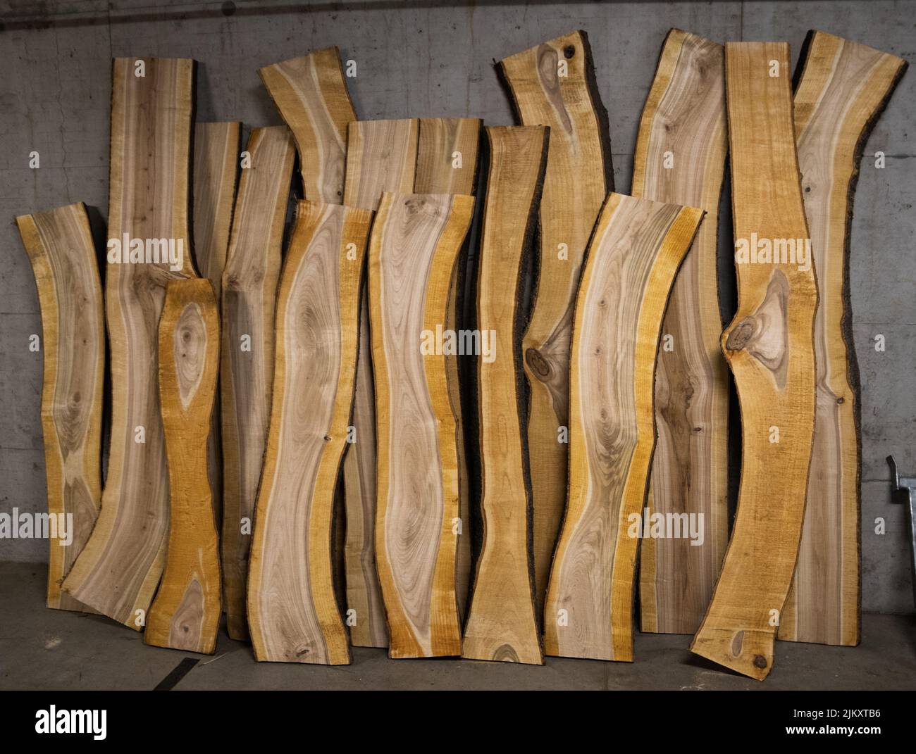 A closeup of cut wooden planks leaning on a dirty rough wall of a ...