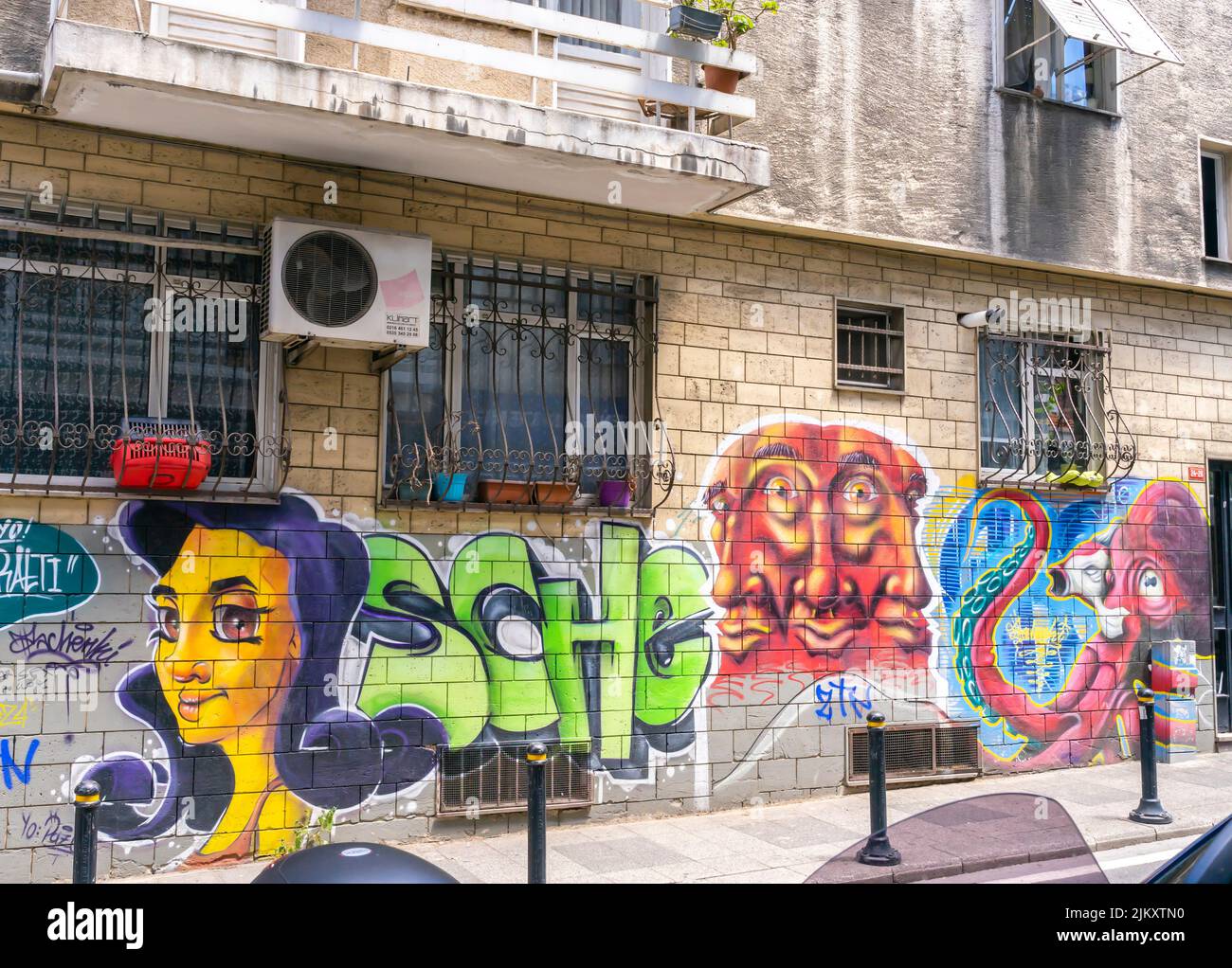 Walls covered with colorful murals depicting animation portraits, faces ...