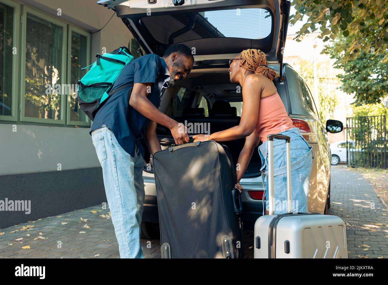 African american couple loading baggage in vehicle to leave on holiday ...