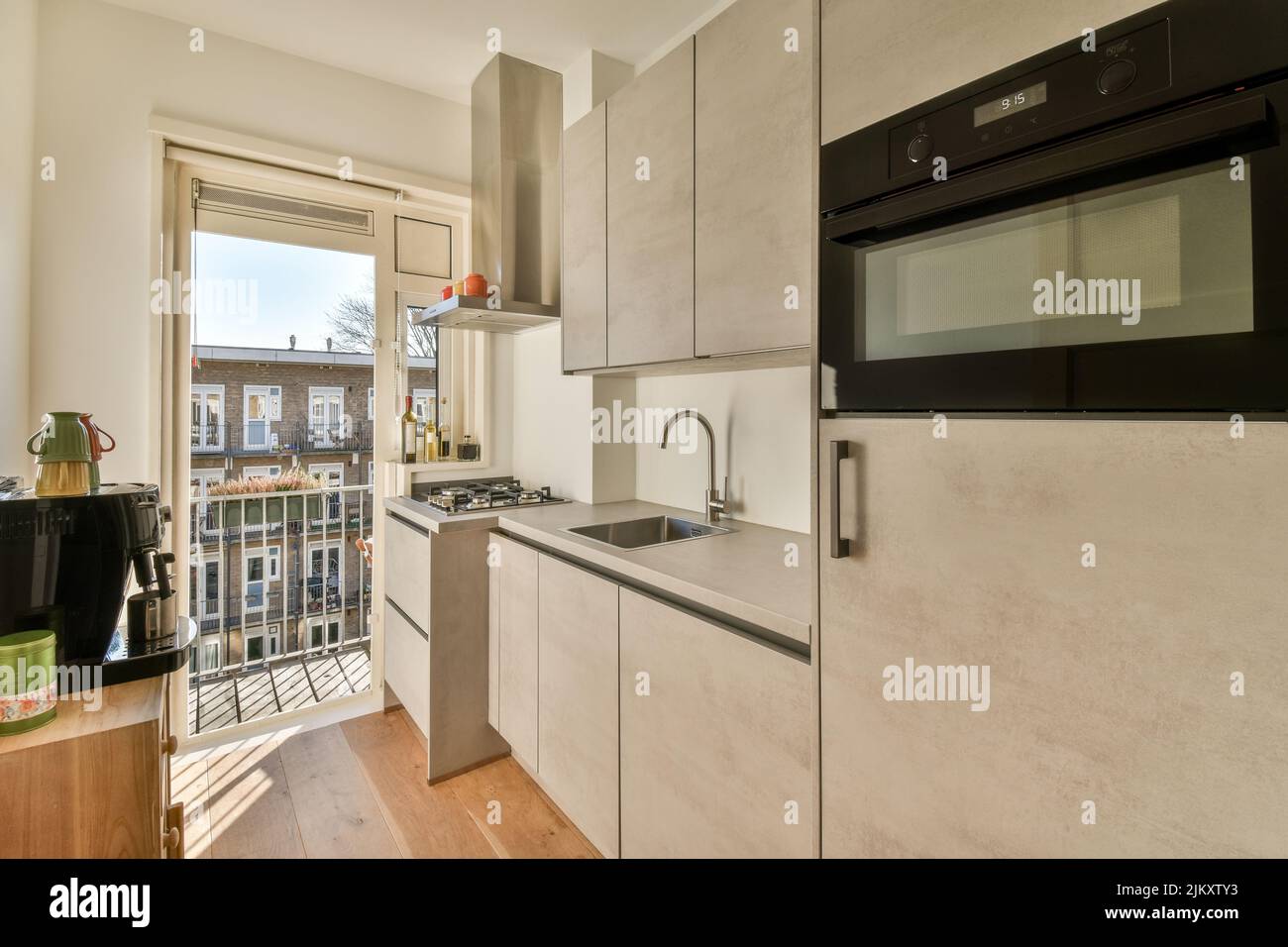 Light small home kitchen with wide window furnished with cupboards and ...