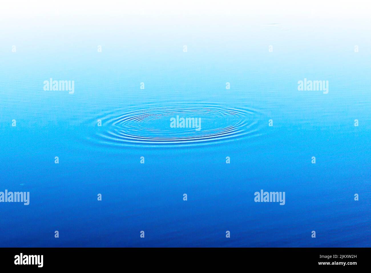 A symbol design of circular waves on the surface of the blue water with ...