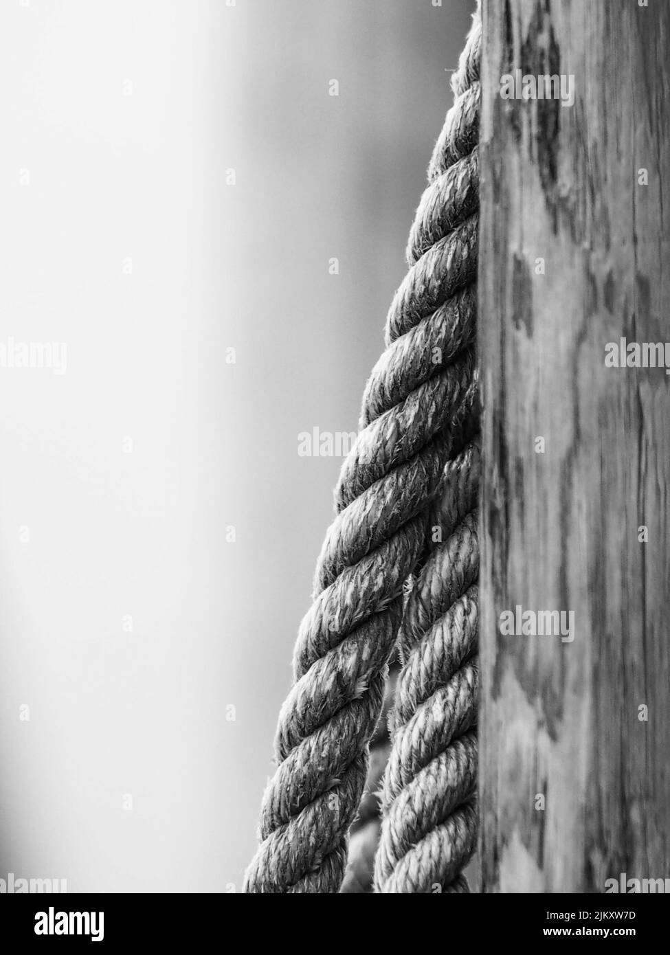 A closeup of a rope tied on the pillar in the blurred background Stock ...