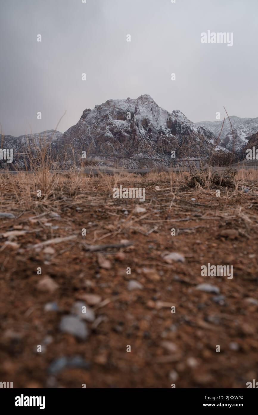 A vertical shot of rocky mountains in a rural area in cloudy sky ...