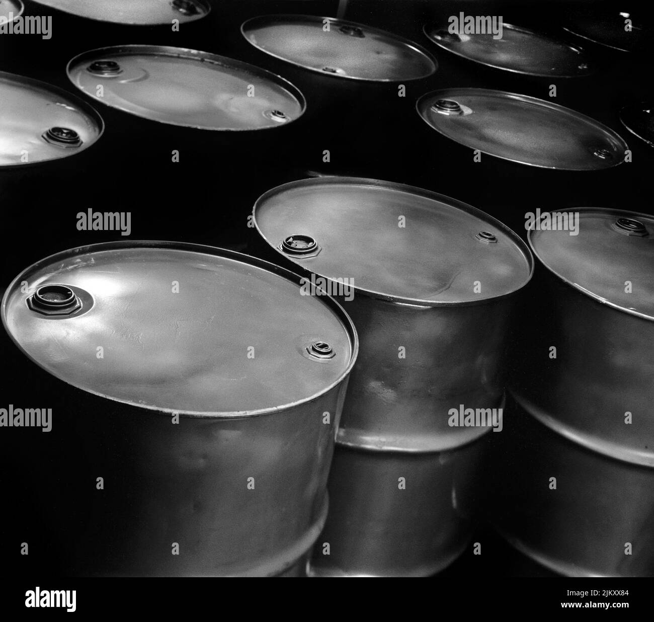 A grayscale shot of many gritty metal oil barrels Stock Photo - Alamy