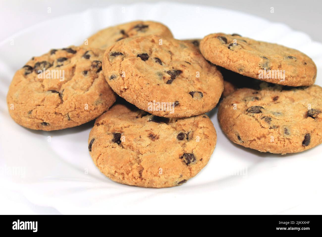 Close up of chocolate chip cookies on a white plate, white background ...