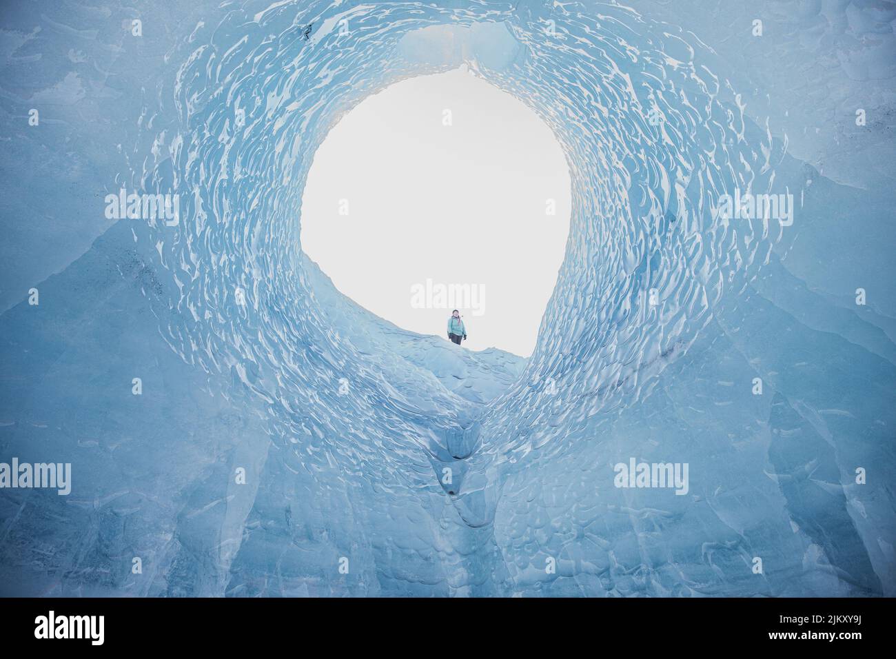 A low angle shot of silhouette of a person looking down into an ice ...