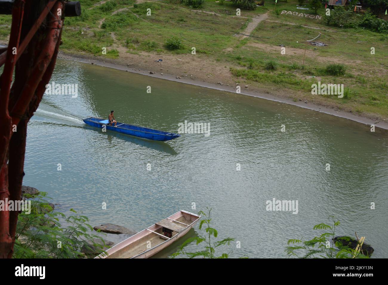 A small blue boat travelling down the Wawa River, Rizal, Philippines ...