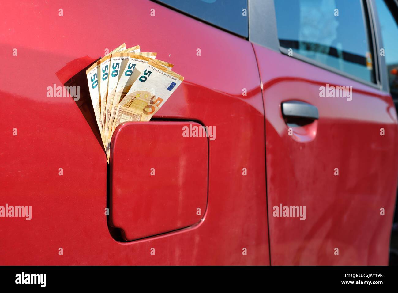 Fifty euro banknotes sticking out of a closed tank cap, high fuel price ...