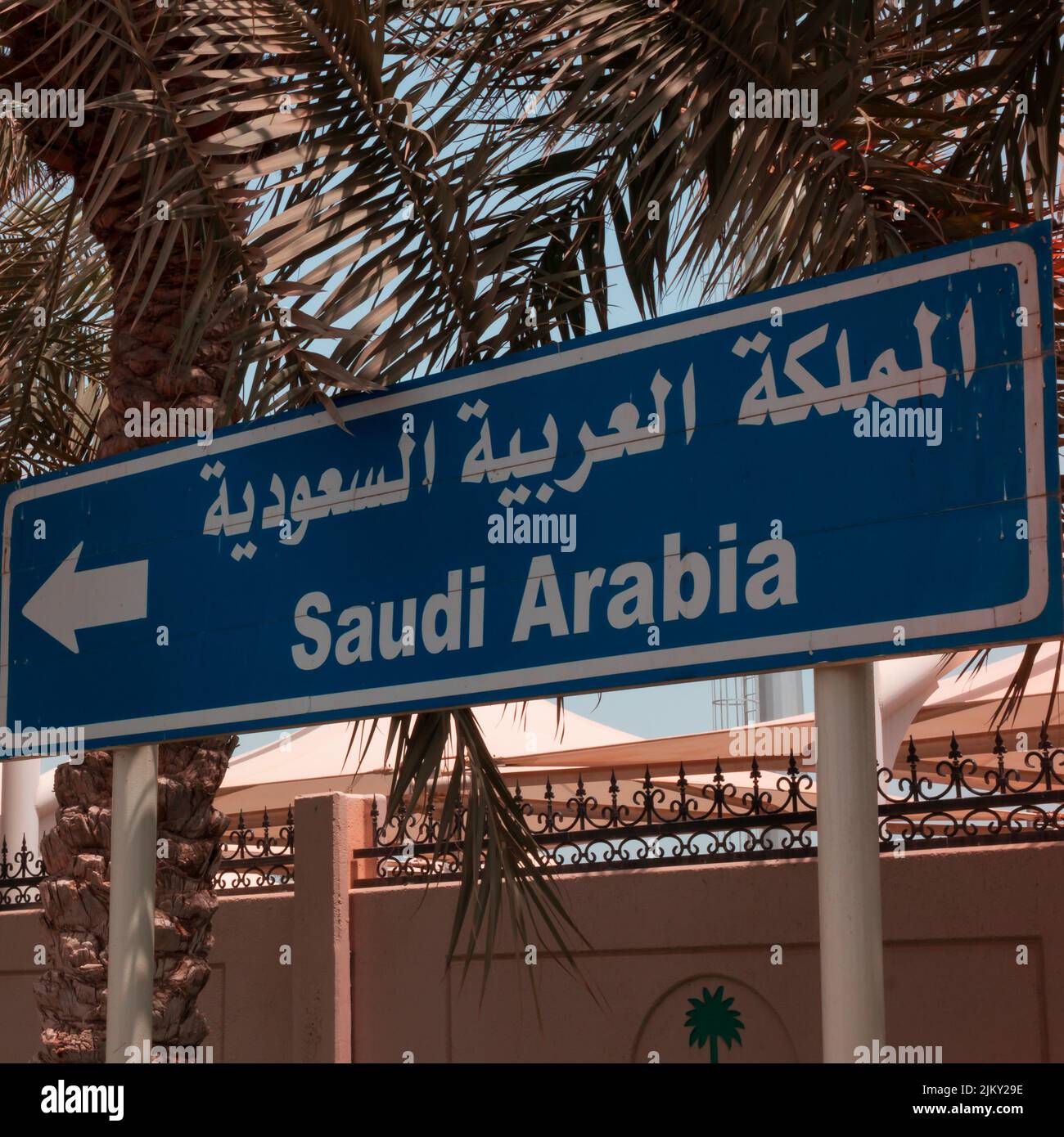 A blue street sign with an arrow pointing to the left, reading Saudi ...