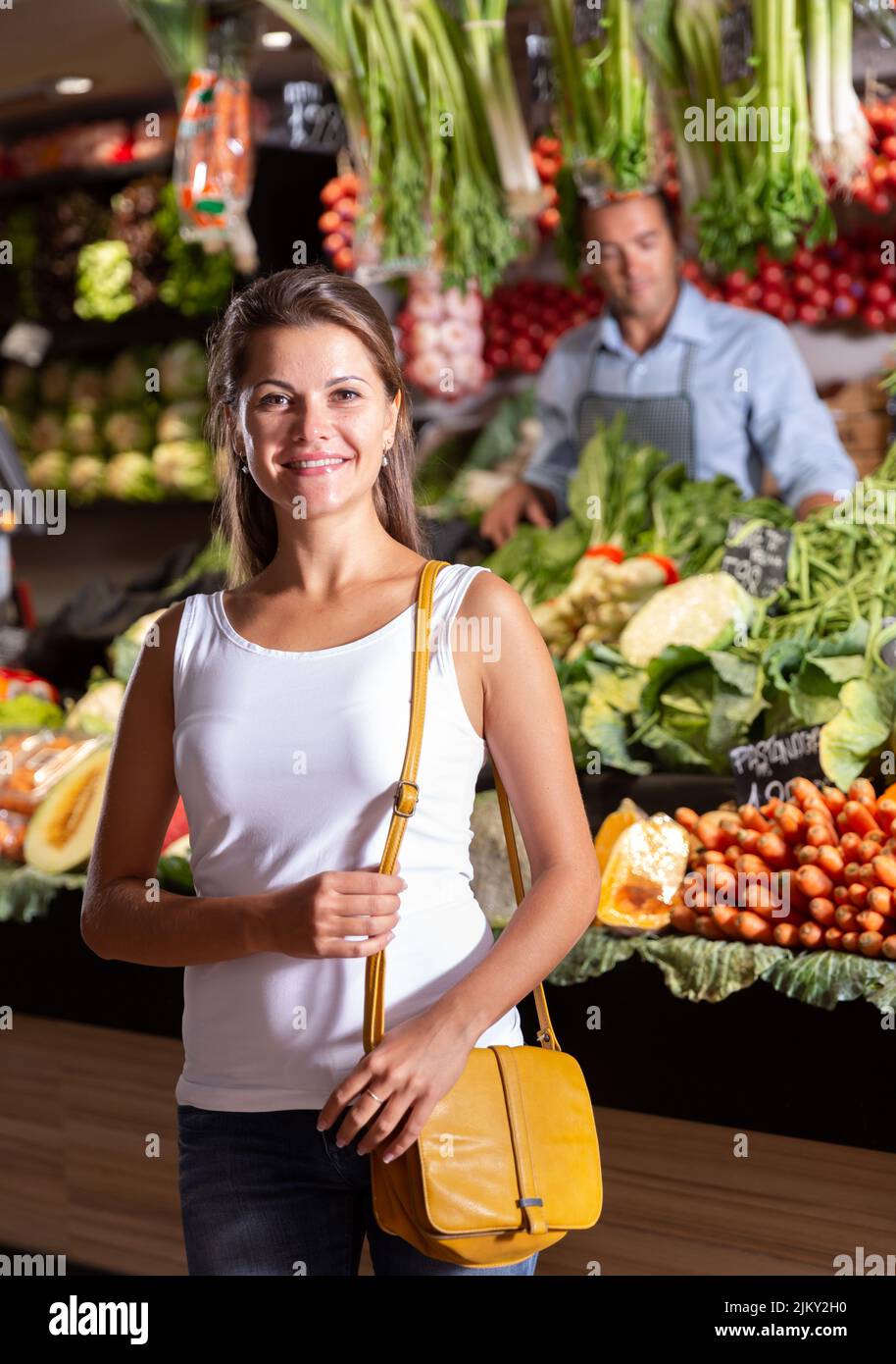 Cheerful female customer standing near counter with fresh fruits Stock ...