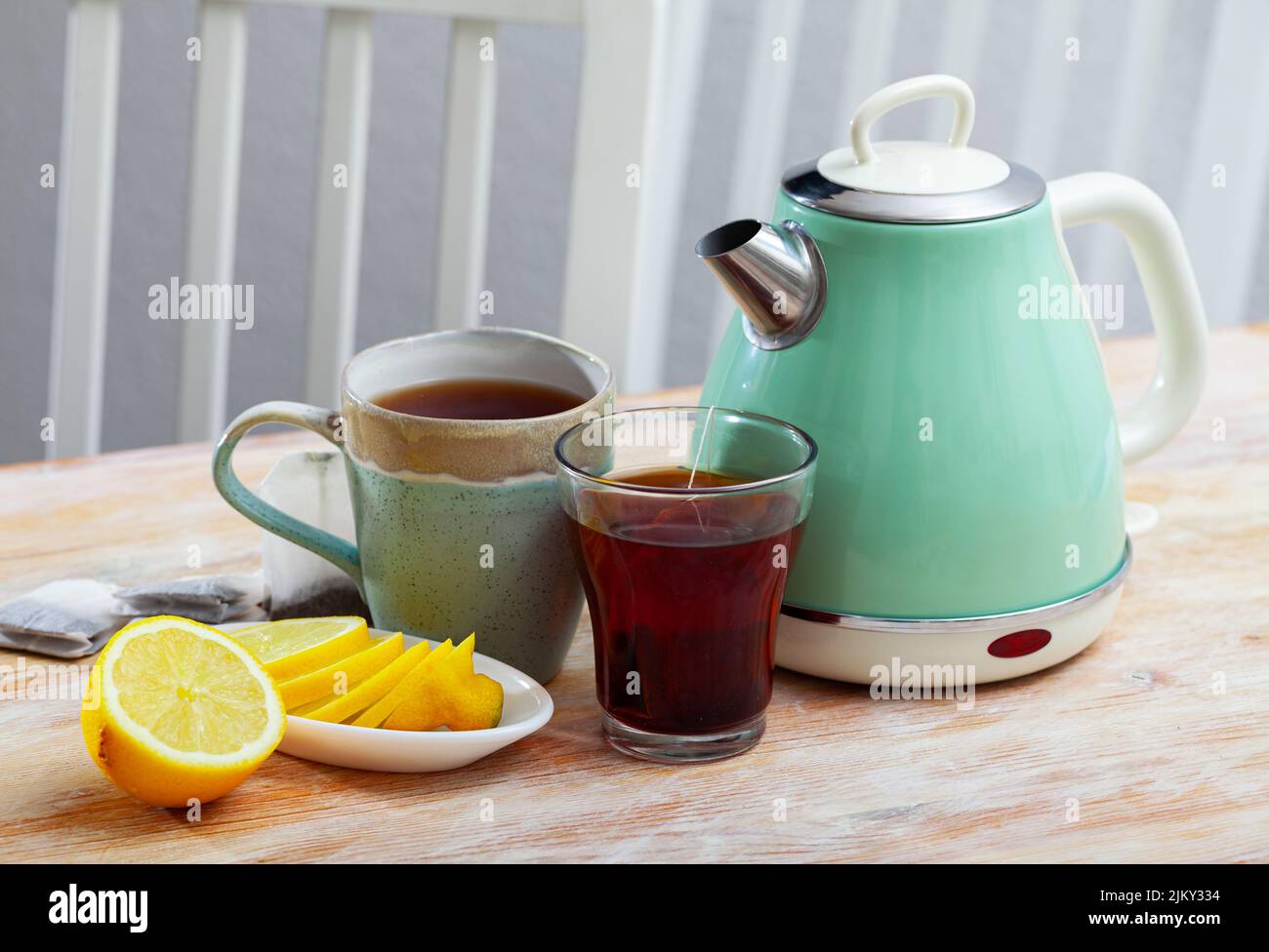 New teapot on table with cup of black tea and sliced lemon Stock Photo ...