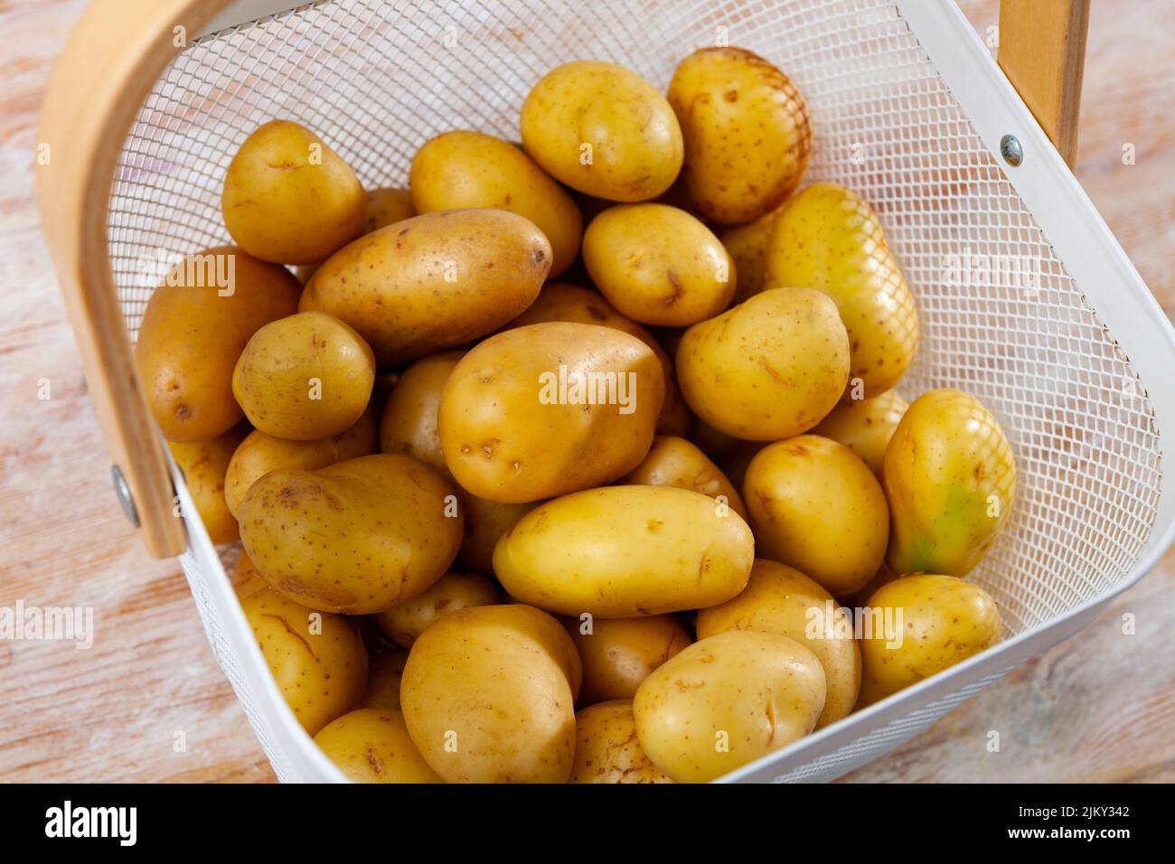 Pile of clean young potato tubers in basket Stock Photo - Alamy