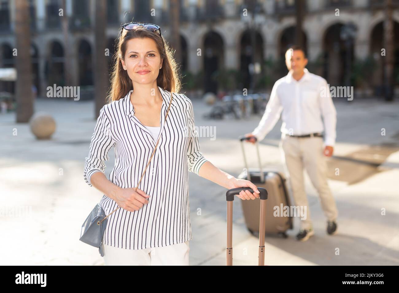 Young woman walking with baggage through city Stock Photo - Alamy