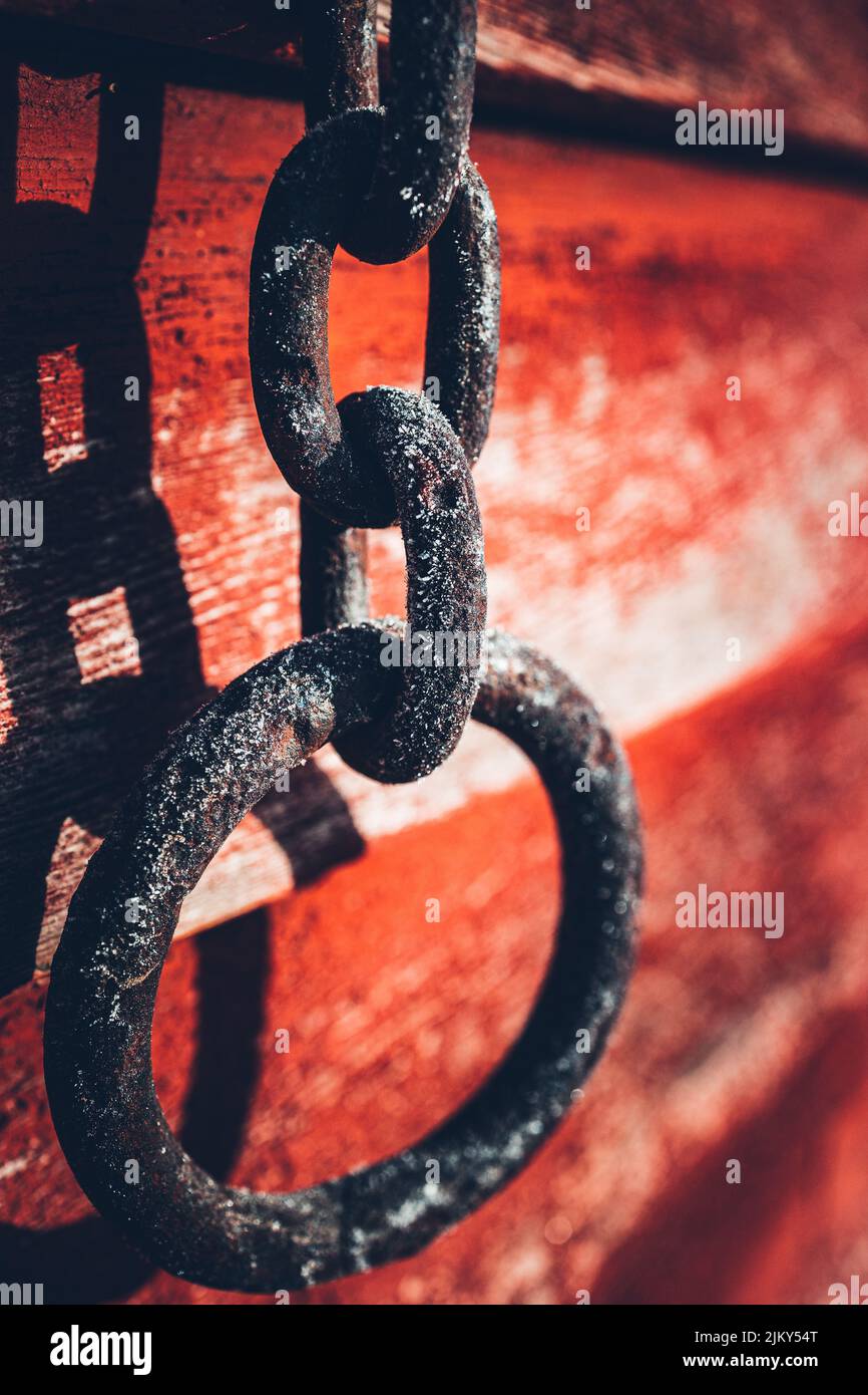 A vertical shot of an iron chain on a red background Stock Photo - Alamy