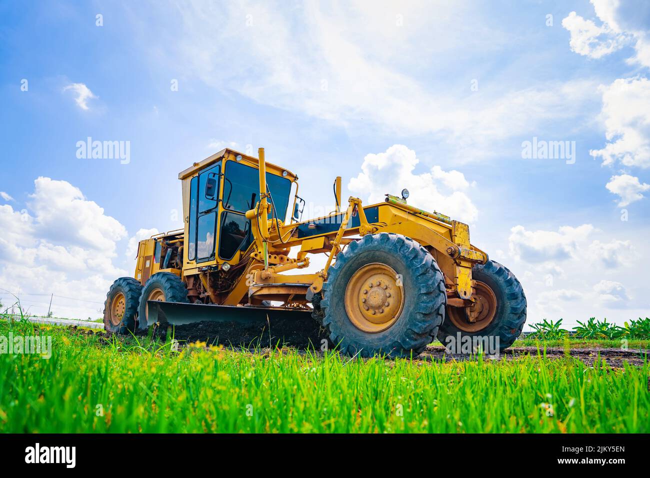 The ground grader is adjusting the road surface evenly to the level ...