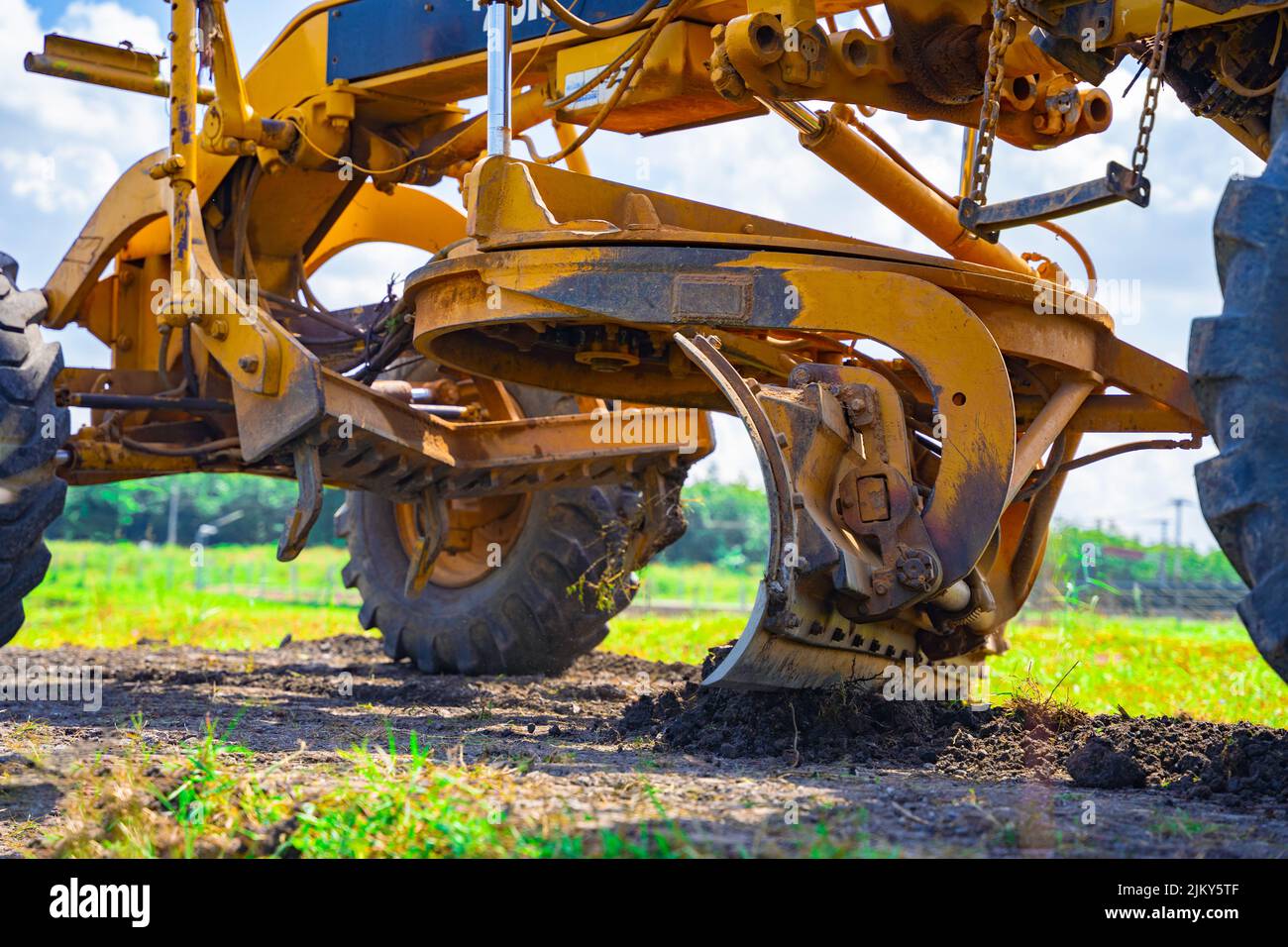 The ground grader is adjusting the road surface evenly to the level ...