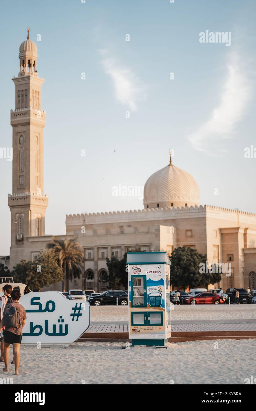 A vertical shot of a beautiful historic building and a book vending ...