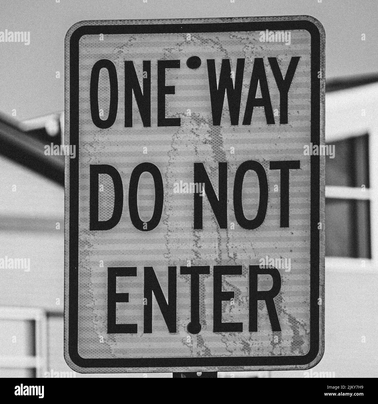 A grayscale shot of sign with the text "one way do not enter Stock ...