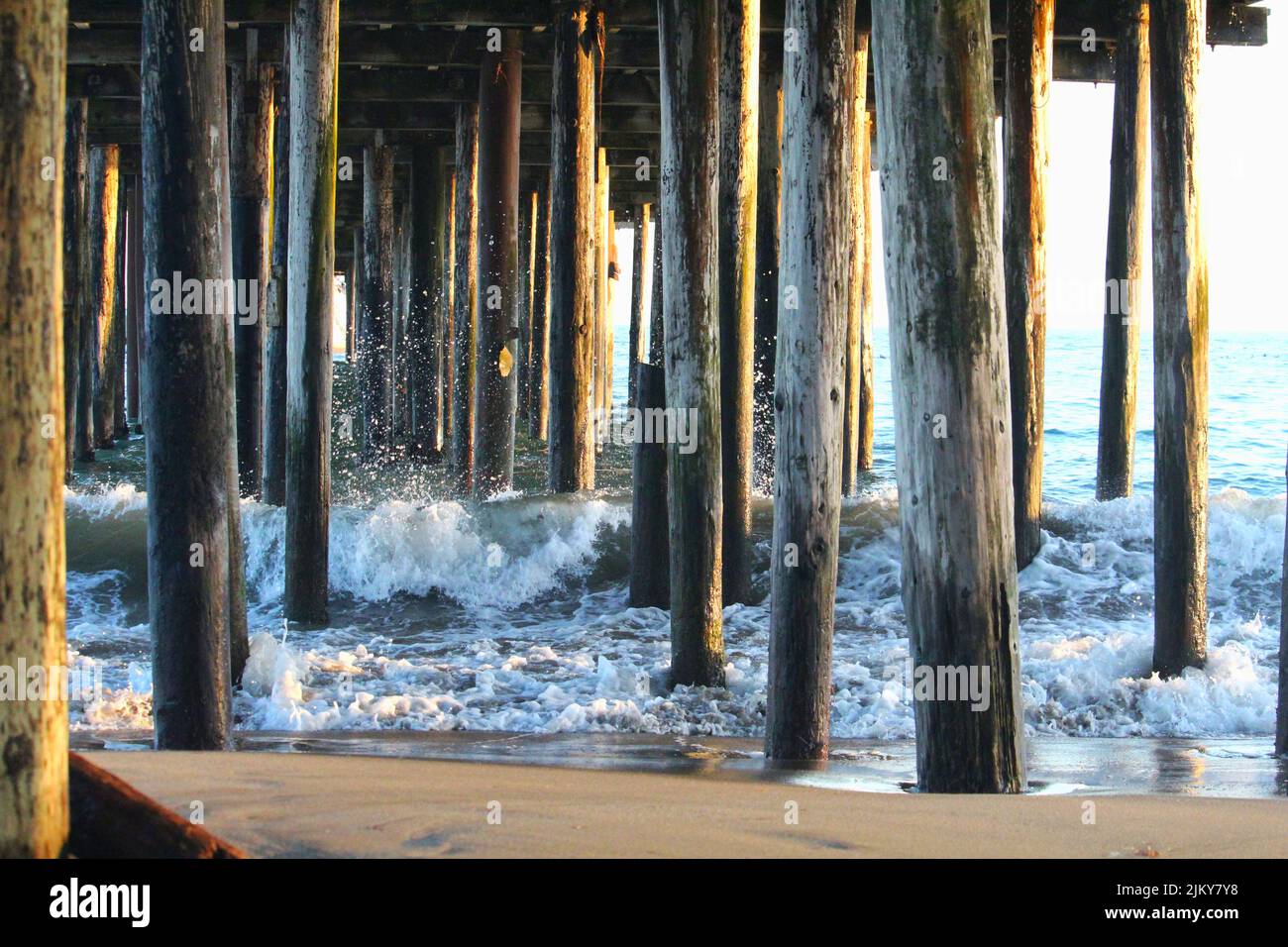 The ocean waves under wooden pier Stock Photo - Alamy