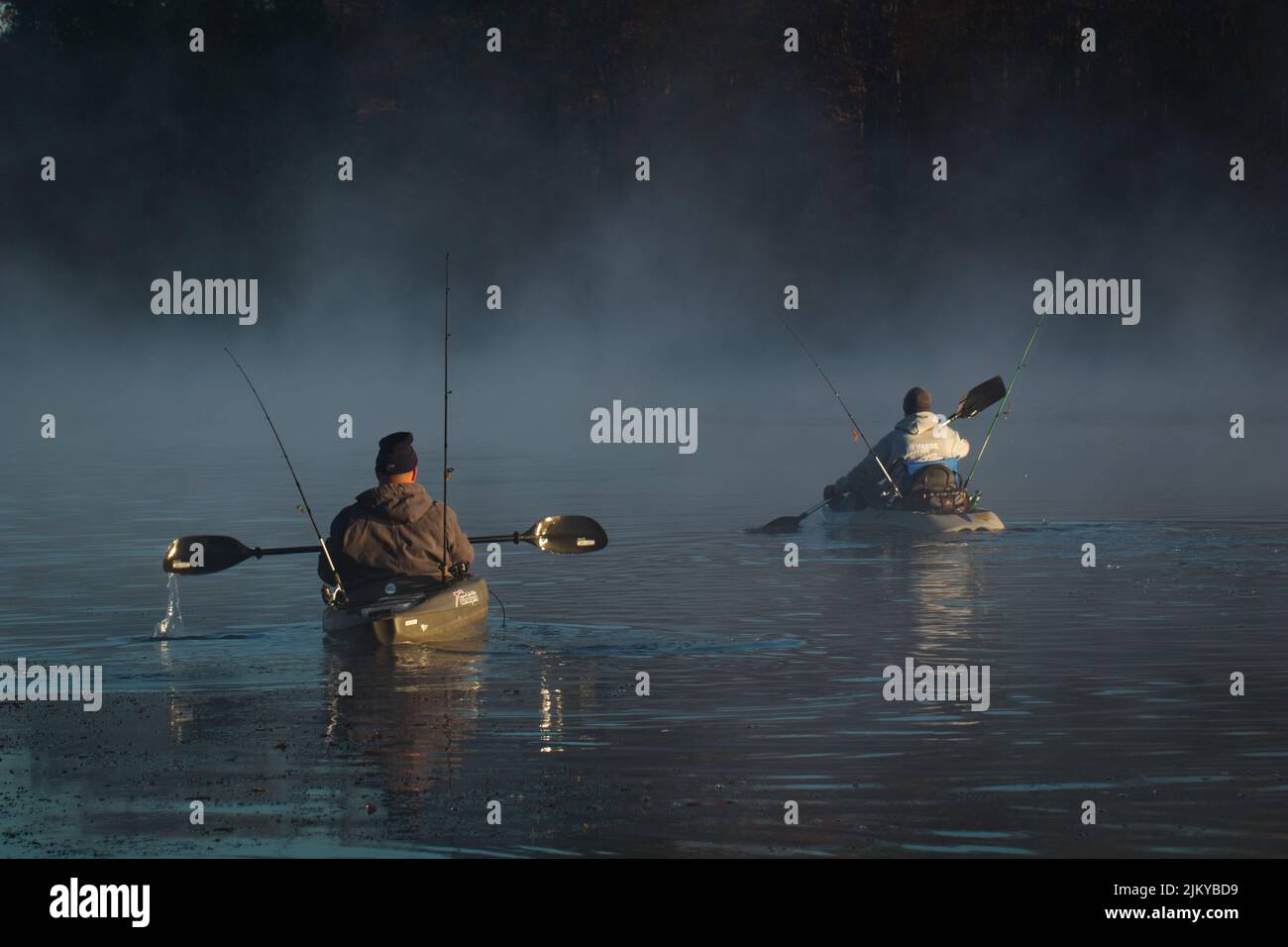 The two young men fishing in a calm lake in boats Stock Photo - Alamy
