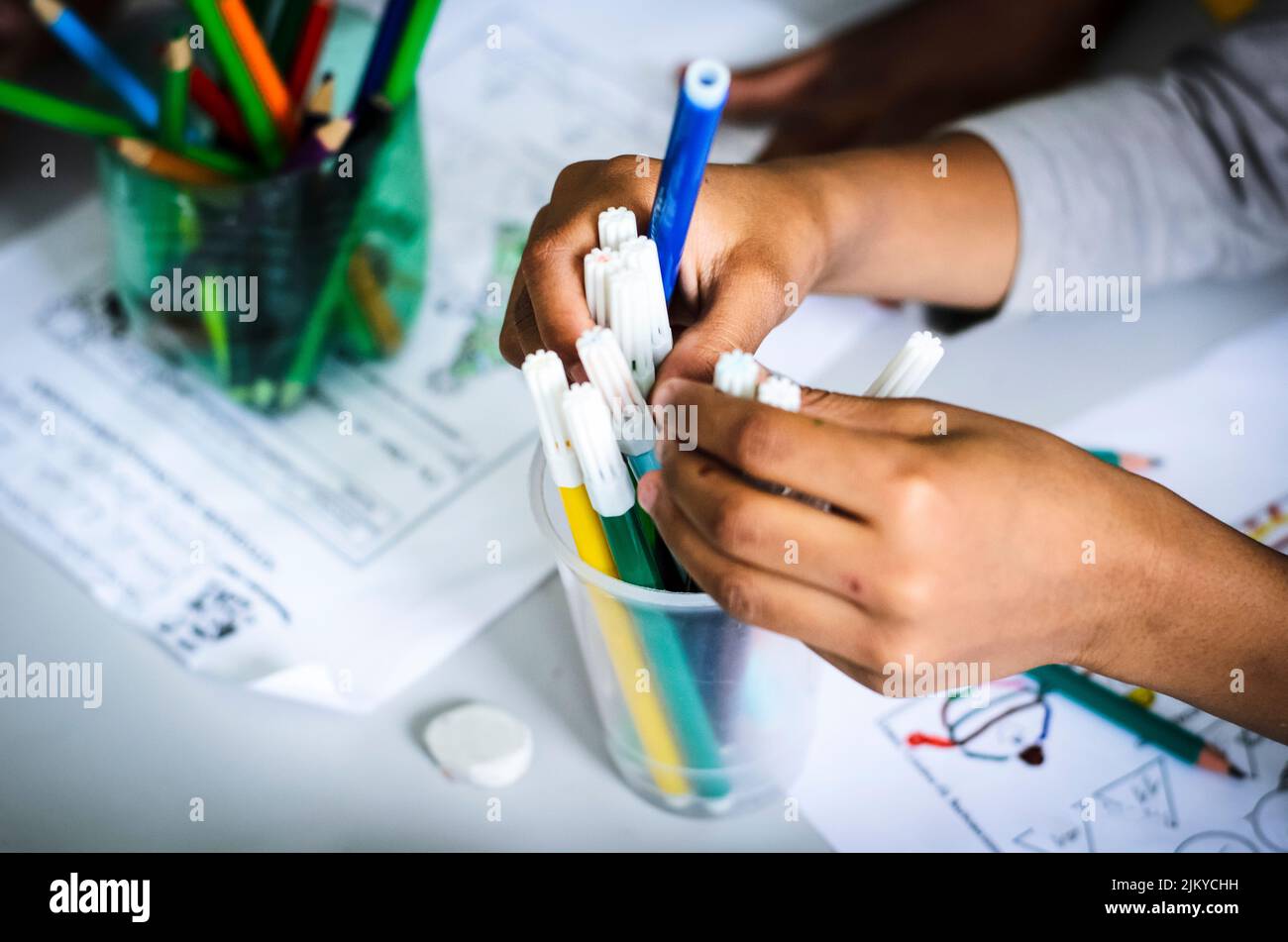 Detail of student hands painting writing with colored pencils. Salvador ...