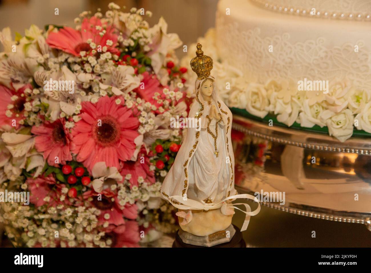 The statue of our Lady of Fatima in front of bouquet of flowers and ...