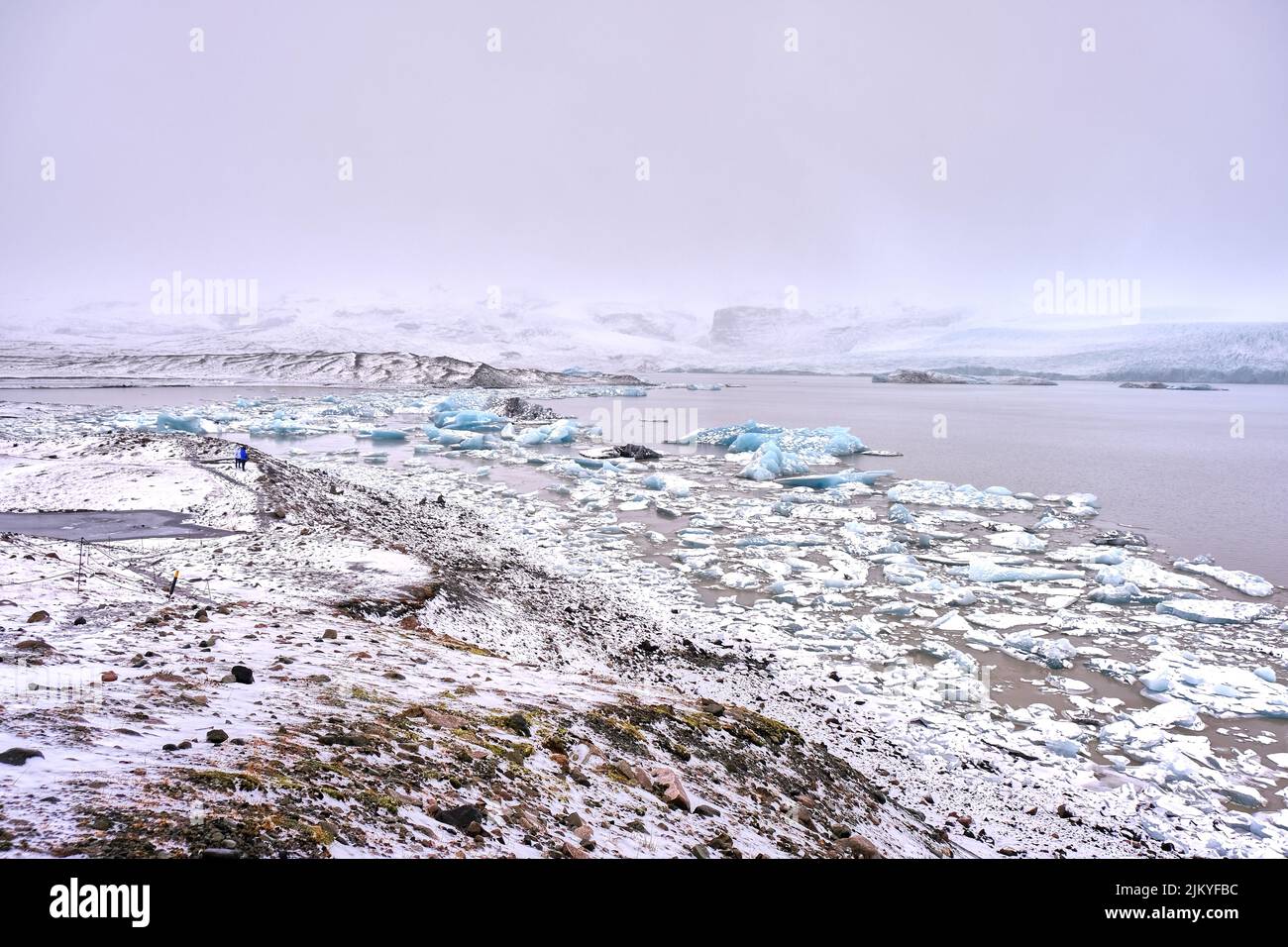 Snowy landscape showing many icebergs floating in Fjallsarlon Glacier ...