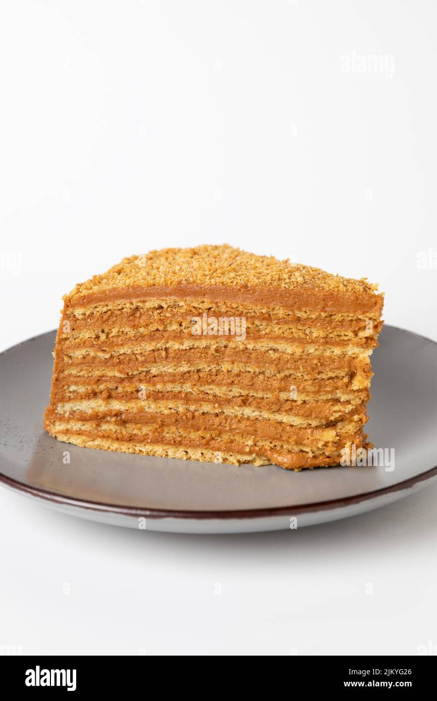 A vertical shot of a slice of a honey cake isolated on a white ...