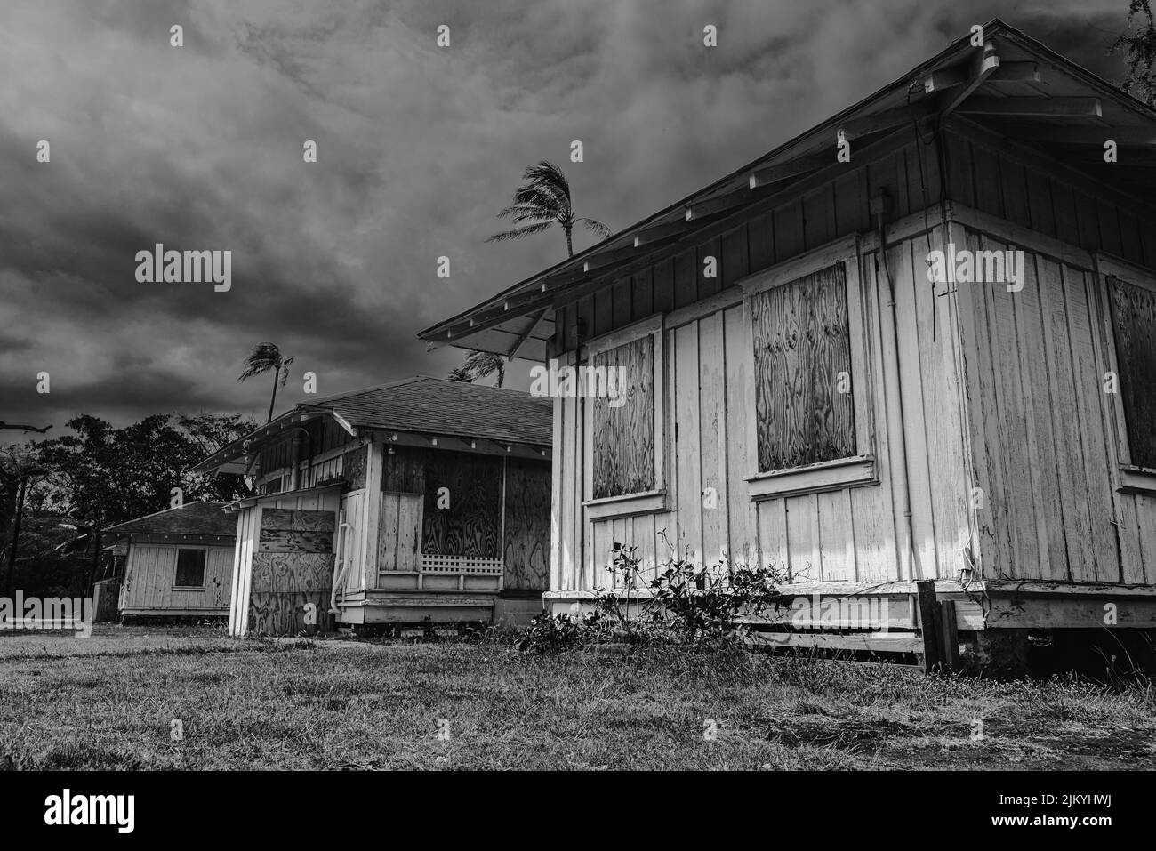 An old wooden house on a farm in grayscale colors with a cloudy sky ...