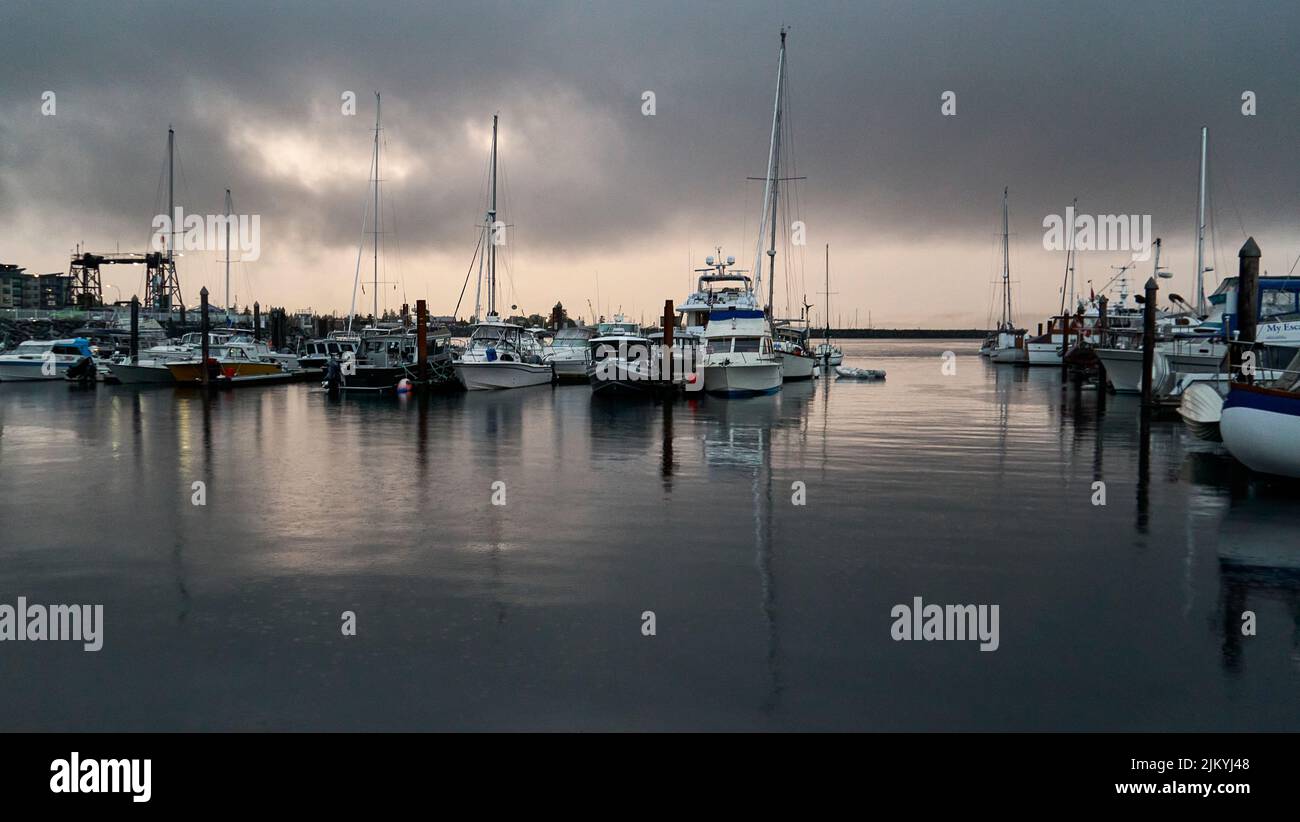 A grey summer evening rain shower at a pleasure craft marina and the ...