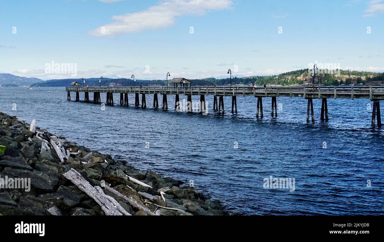 The wooden fishing pier, a popular place to walk, in the early evening ...