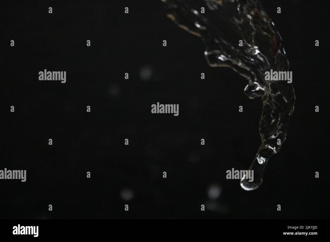 A close up on water flow against a black background Stock Photo - Alamy