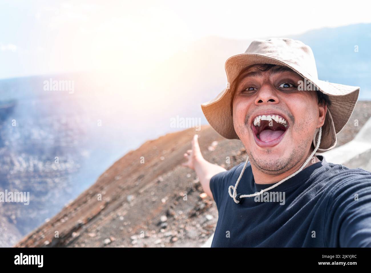 Latin man smiling taking a self portrait visiting a volcano Stock Photo ...