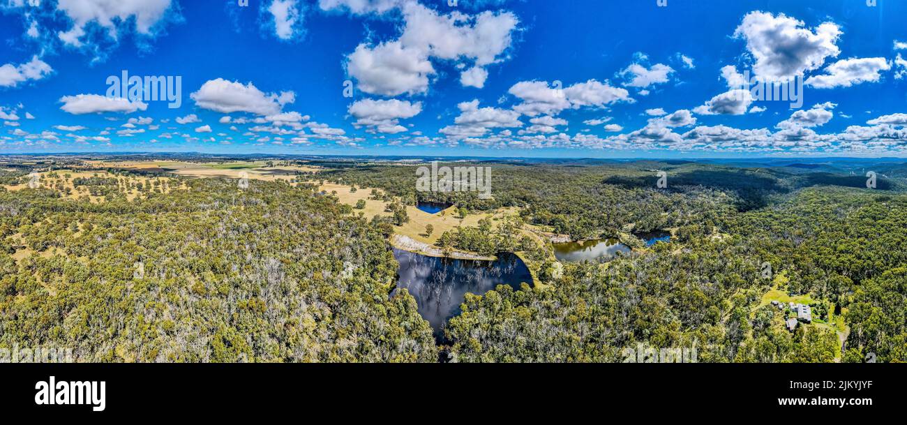 An aerial view of the old mine that is a dam now with green trees on ...