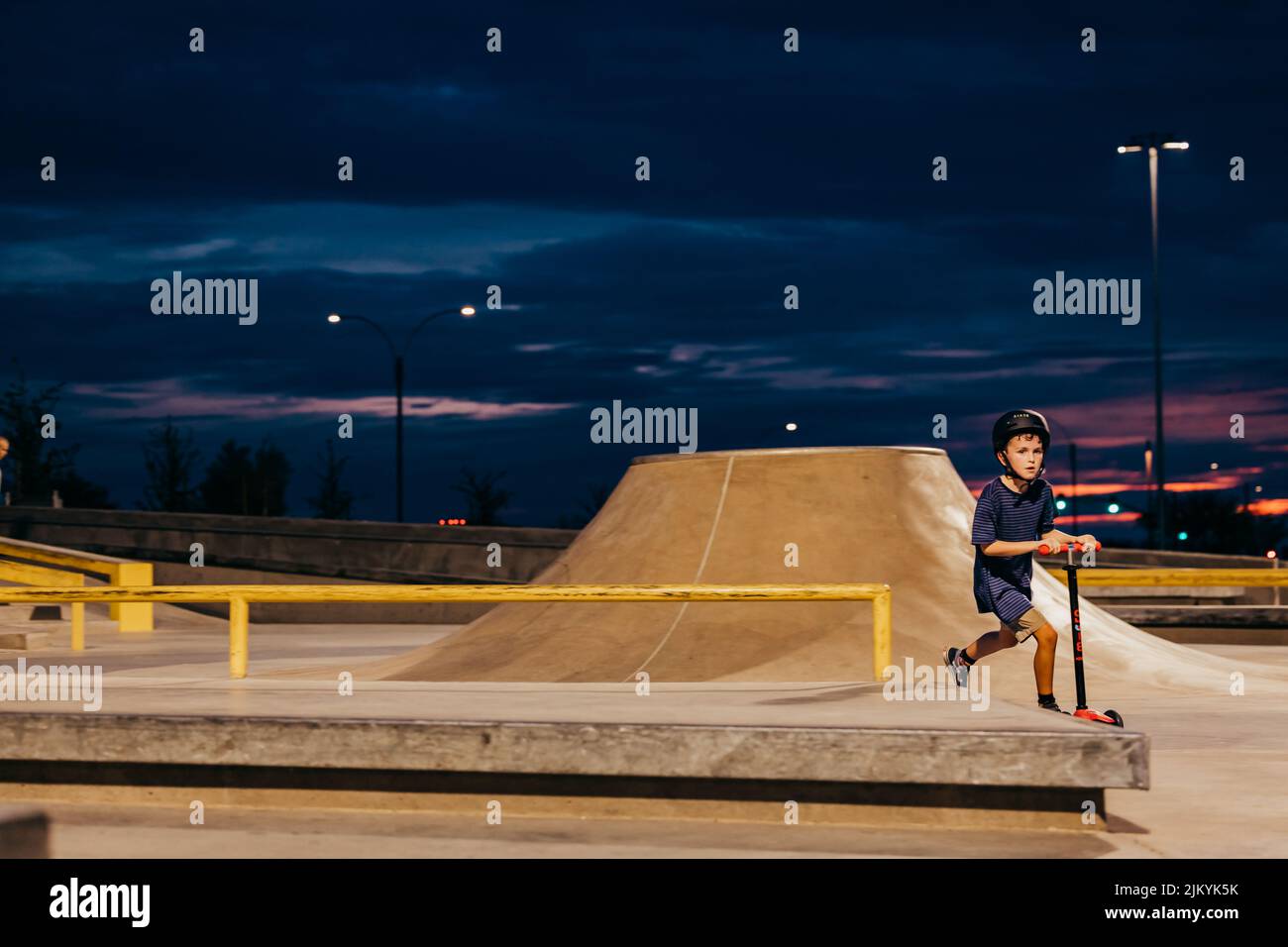 Boys Riding at a Skatepark at sunset and night. Riding Skateboards ...