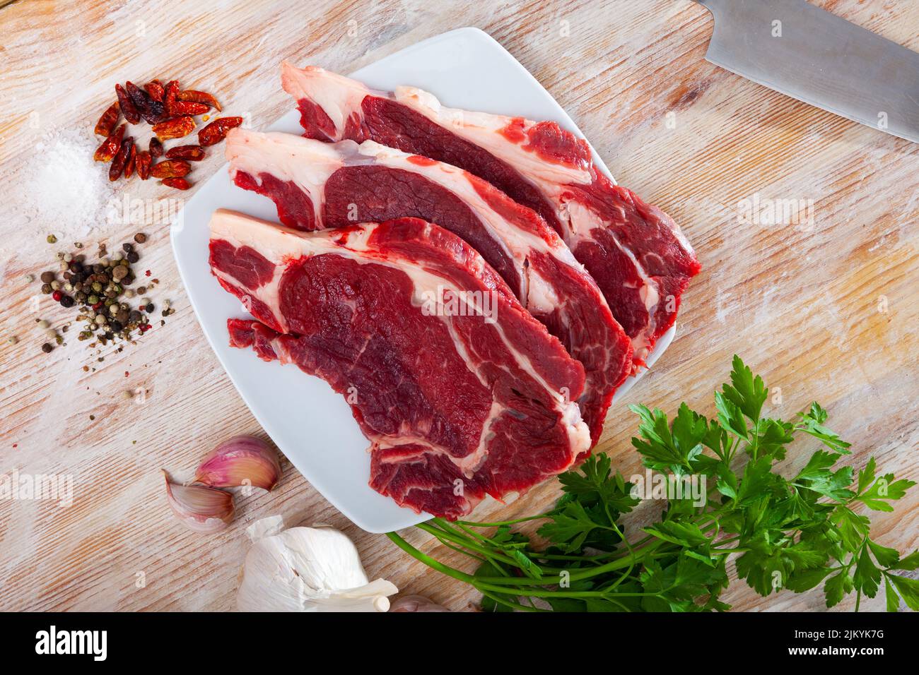 Raw beef fillet with onion and pepper ready for cooking on table Stock ...
