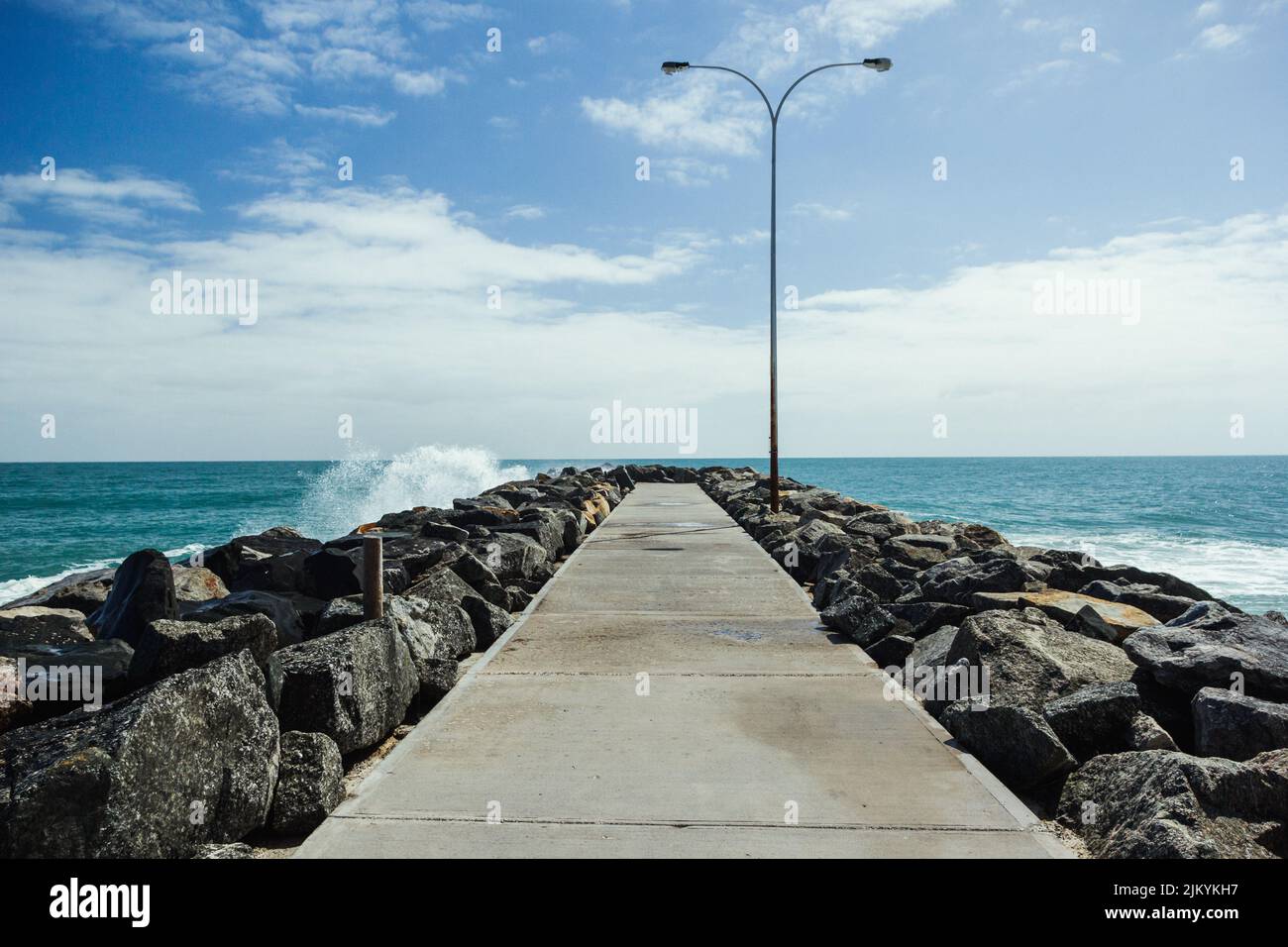 Samll wave hitting a rocky jetty Stock Photo - Alamy