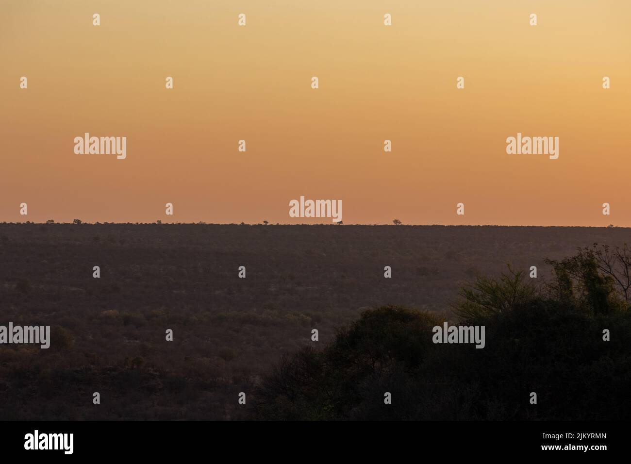 A beautiful orange dusky sky over a field in South Africa Stock Photo ...