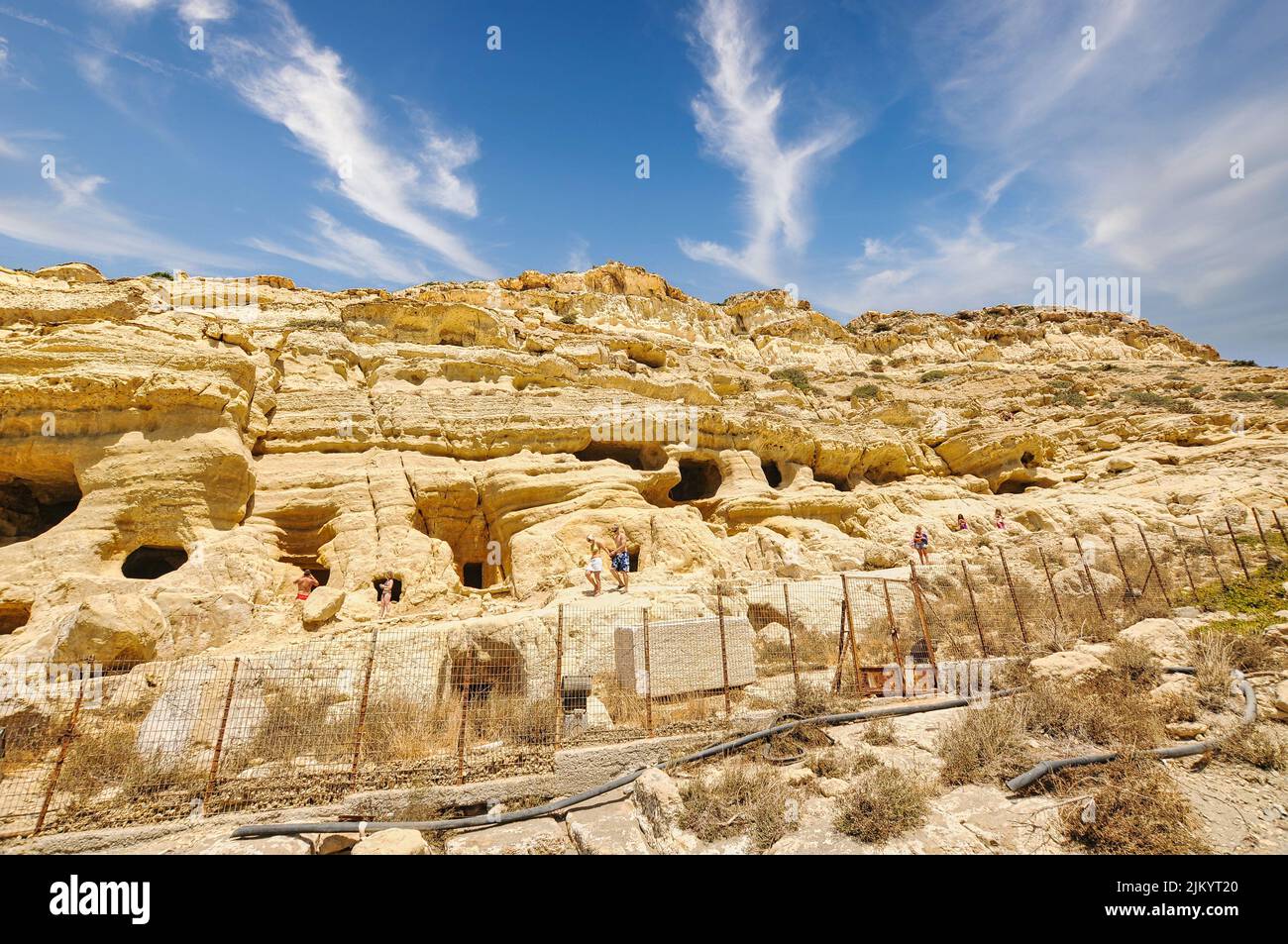 Matala beach with caves on the rocks that were used as a roman cemetery ...