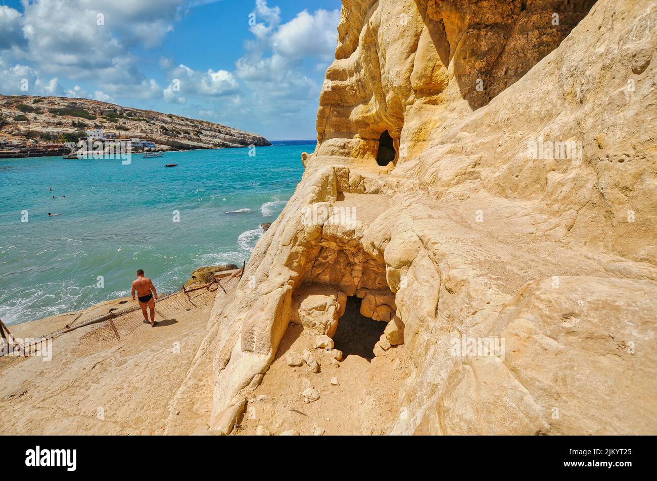 Matala beach with caves on the rocks that were used as a roman cemetery ...