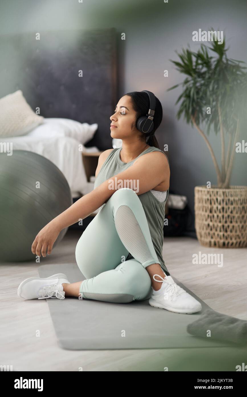 Getting a healthy start to her day. a sporty young woman listening to ...
