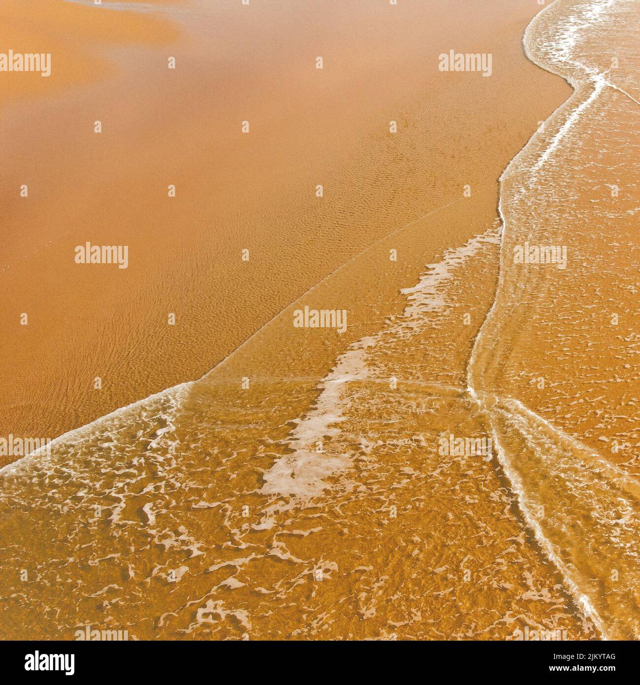 Seafoam on sandy beach hi-res stock photography and images - Alamy
