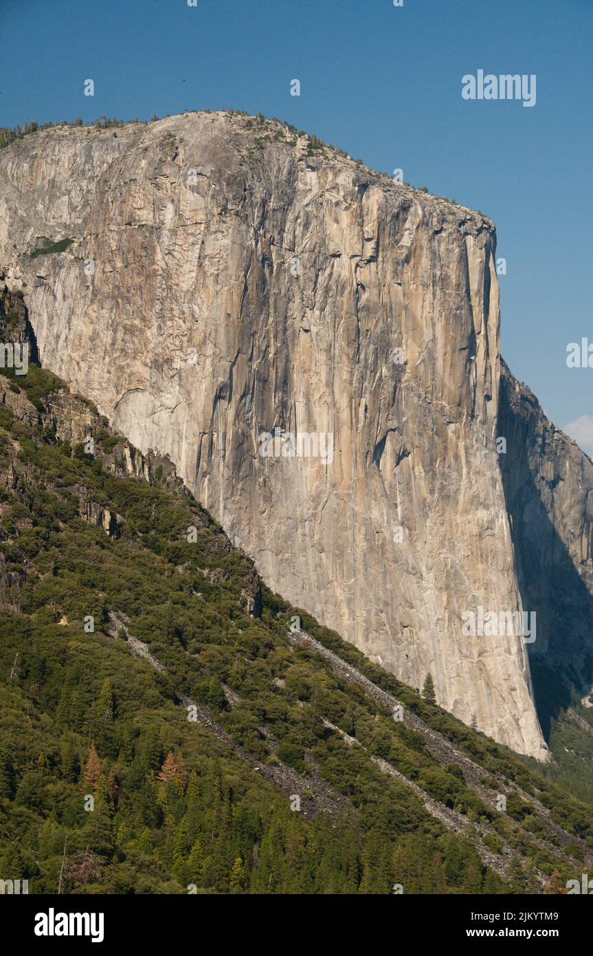 A closeup of a mountain cliff against a clear blue sky in Yosemite ...
